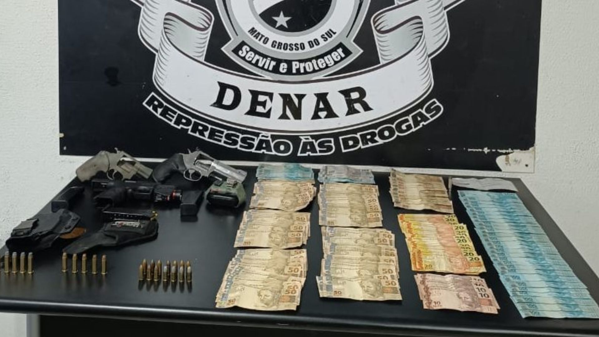 Armas e dinheiro apreendidos durante a operação. (Reprodução, Denar)
